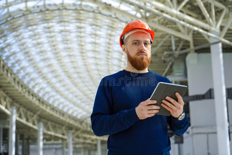 A Man in a Helmet in a Large Space with a Tablet Stock Image - Image of ...