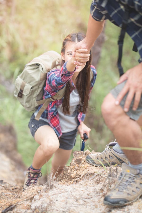 Man Help Pull a Woman`s Hand in Hiking Activities on the Mountai Stock ...