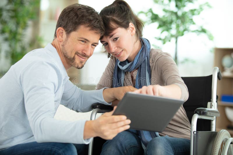 Man Helping Disabled Wife To Use Tablet Pc at Home Stock Photo - Image ...