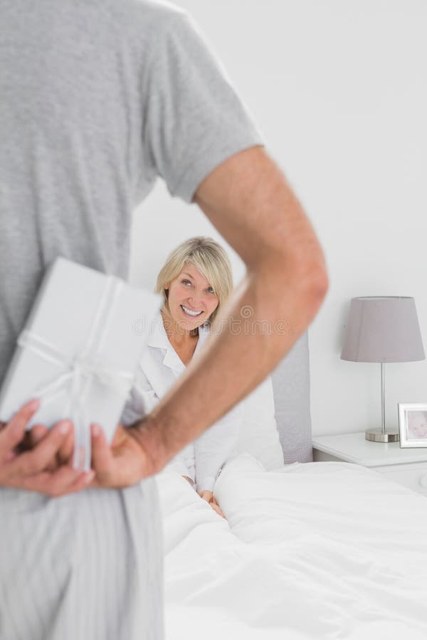 Man Hiding Present Behind His Back for Smiling Partner Stock Photo ...