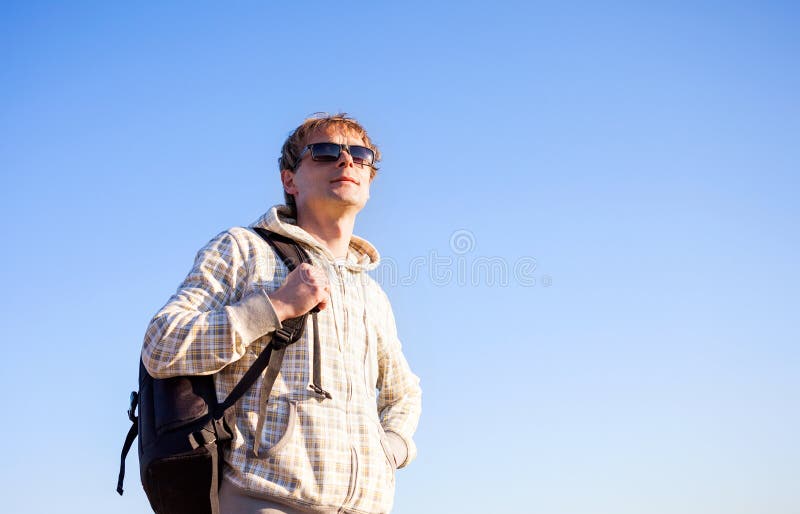Man Hiker Holding Backpack on a Sunny Day Against a Blue Sky Stock ...
