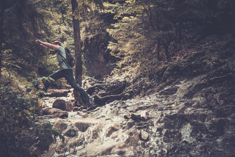 Man Hiker Jumping Across Stream Stock Photo - Image of extreme ...