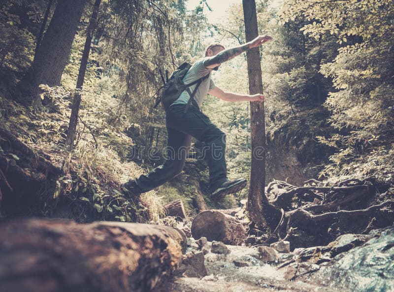 Hiker Jumping from Rock To Rock Stock Photo - Image of leisure, danger ...