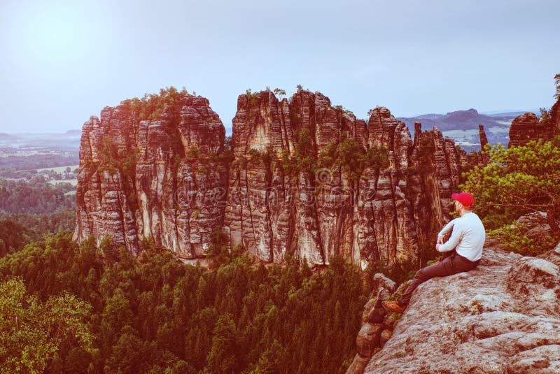 Man Hiker with Red Cap on Rock and Looks at Sharp Mountain Stock Image ...