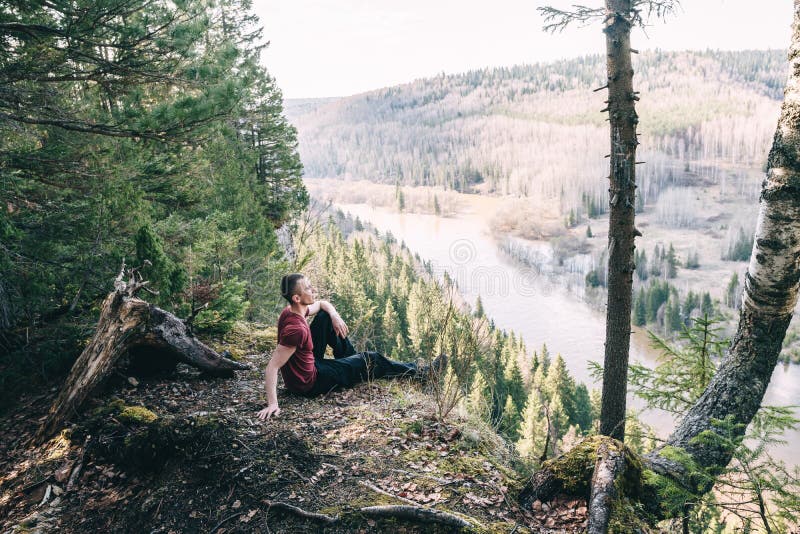 A Man Hiker Sitting on a Cliff Edge Enjoying Scenic View Stock Image ...