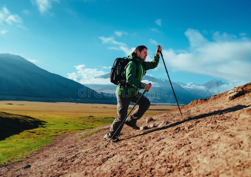 Man Hiker with Trekking Poles and Backpack Climbing Up the Mountain ...