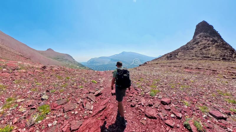 Man Hikes Over Red Rocks on Pass in Glacier Stock Video - Video of blue ...