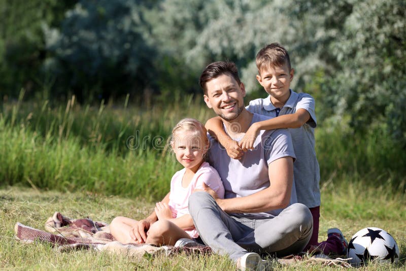 Man with His Little Children Resting in Park Stock Photo - Image of ...