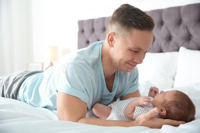 Man with his newborn baby stock photo. Image of bedroom - 142237366