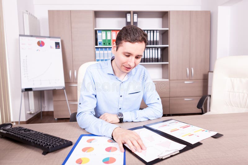 Man in His Offce with Charts Folders on Table Stock Image - Image of ...