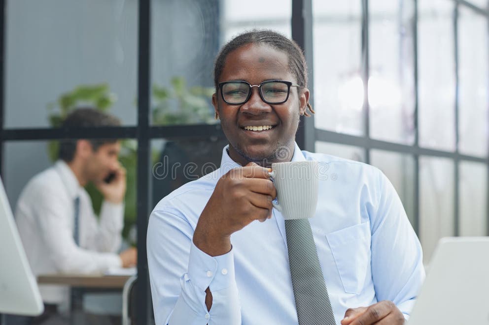 A Man at His Workplace at a Table in Front of a Computer Drinks Coffee ...