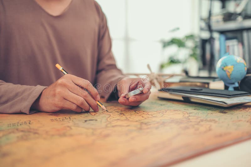 A Man Hold Compass and Checking Road Map and World Map before Travel ...