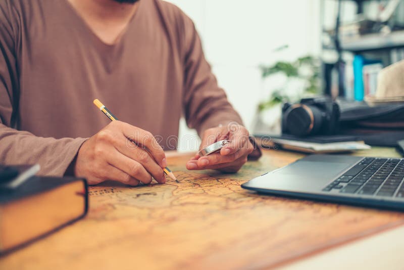 A Man Hold Compass and Checking Road Map and World Map before Travel ...
