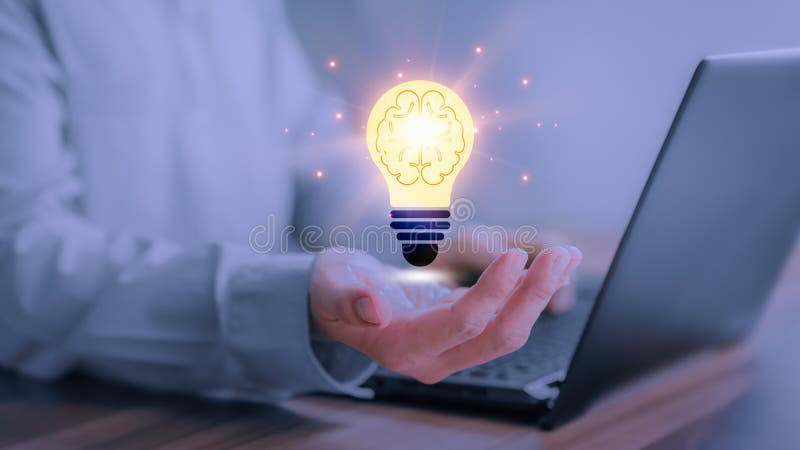 Man Holding a Abstract Light Bulb while Working on the Computer To ...