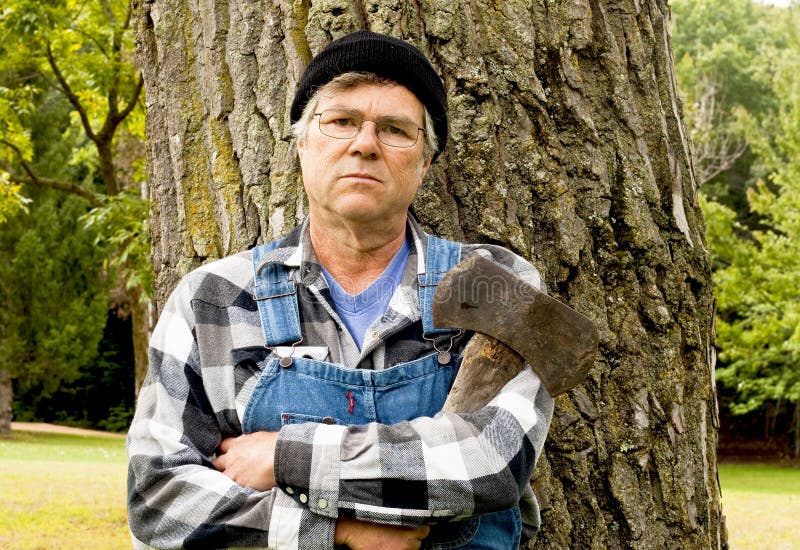 Man Holding an Axe Leaning Against a Tree Stock Image - Image of male ...
