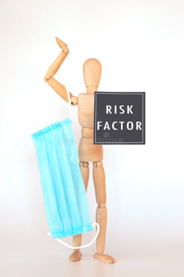 A Man Holding a Blue Face Mask with the Words Risk Factor Written Below ...