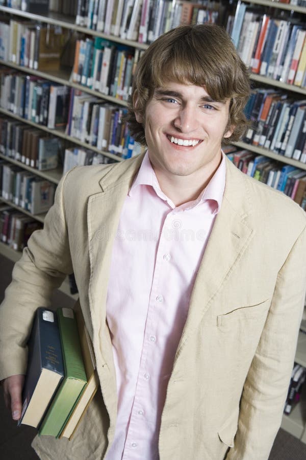 Man Holding Books in the Library Stock Photo - Image of smile, smiling ...