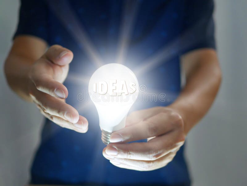 Man Holding Bright Shining Light Bulb Represents a New Idea, Thought ...