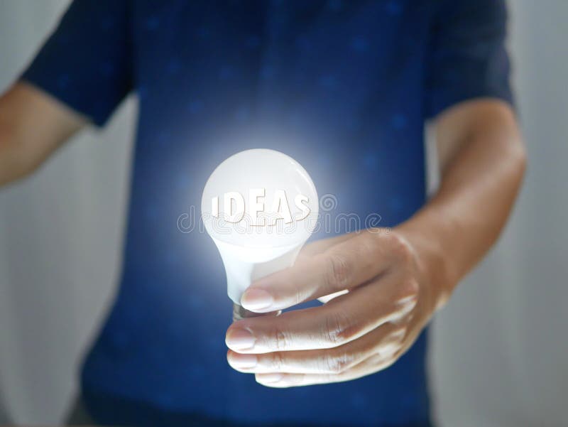 Man Holding Bright Shining Light Bulb Represents a New Idea, Thought ...