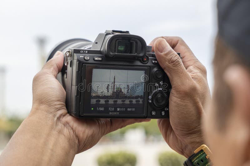 A Man Holding a Camera, Capturing the Scenic Putra Mosque in Putrajaya ...
