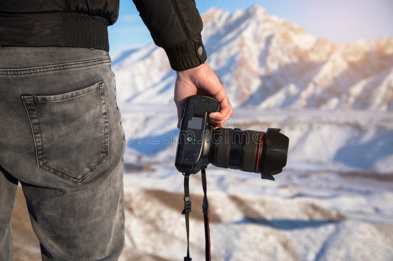 Man Holding Camera in Winter Stock Photo - Image of hand, mountains ...