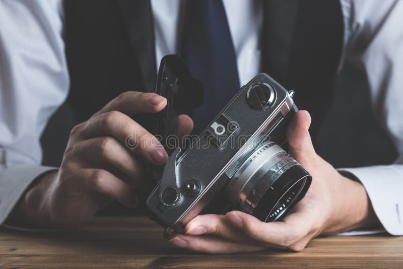 A Man Holding a Camera on the Table Stock Image - Image of money, lens ...
