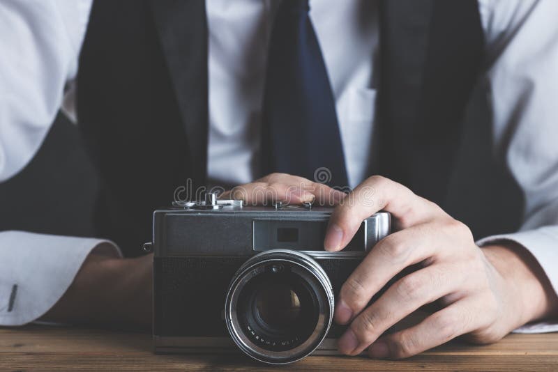 A Man Holding a Camera on the Table Stock Photo - Image of lens ...