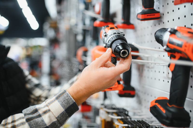 Man Holding and Choosing Electric Screwdriver, Standing in Construction ...