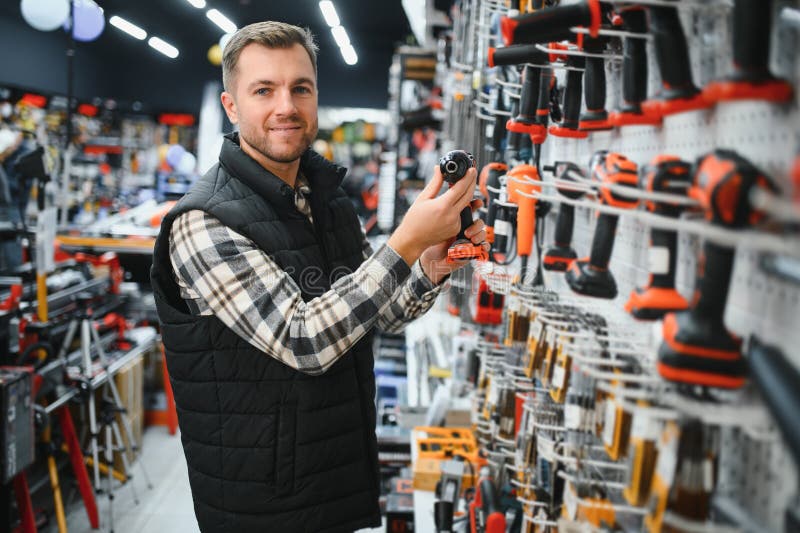 Man Holding and Choosing Electric Screwdriver, Standing in Construction ...