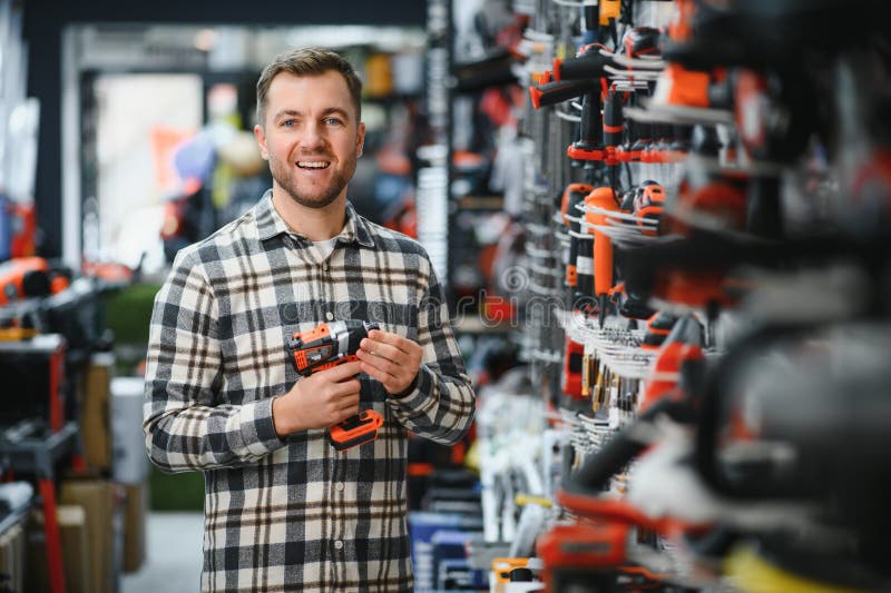 Man Holding and Choosing Electric Screwdriver, Standing in Construction ...
