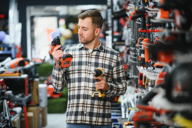 Man Holding and Choosing Electric Screwdriver, Standing in Construction ...
