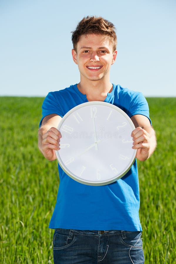 Young Handsome Man Showing Big Clock, Smiling Stock Image - Image of ...