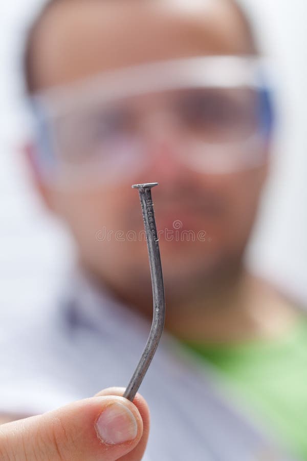 Man Holding Crooked Nail - Closeup on Nail Stock Photo - Image of ...
