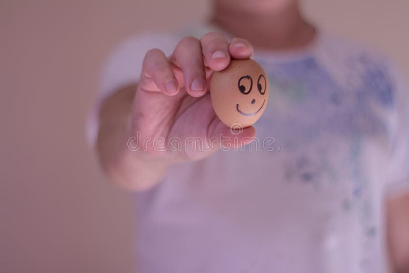 A Man Holding an Egg with a Funny Face. Conceptual Image Stock Photo ...