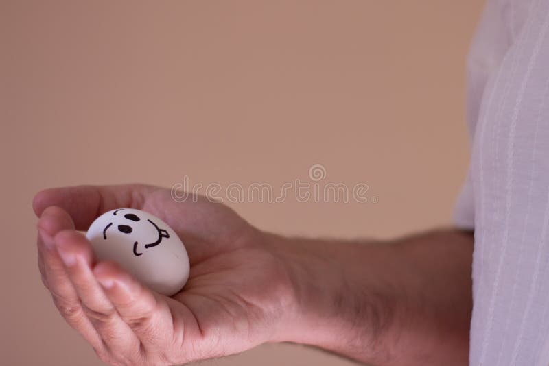 A Man Holding an Egg with a Funny Face. Conceptual Image Stock Image ...