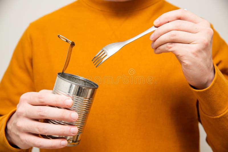 Man Holding a Fork and Opened Tin Can Stock Photo - Image of orange ...
