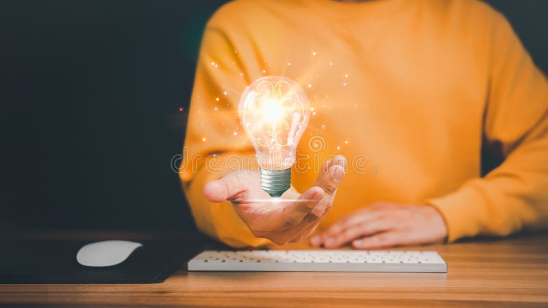 Man Holding a Glowing Abstract Light Bulb with a Computer Keyboard on ...