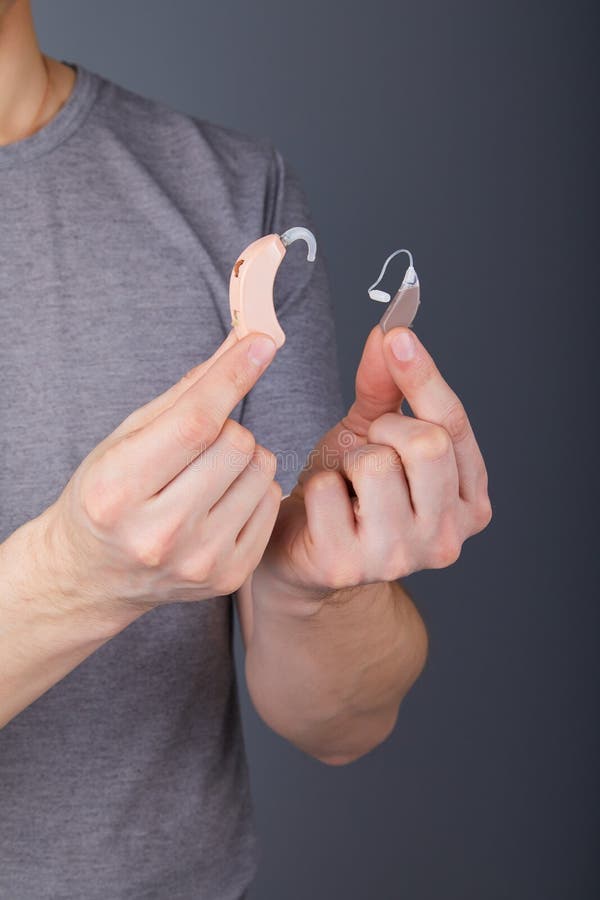 Man Holding Hearing Aid, Closeup. Stock Photo - Image of concept ... Man Holding Hearing Aid, Closeup. Stock Photo - Image of concept ...
