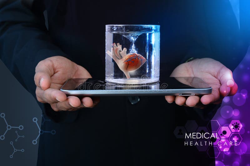 Man is Holding a Heart in Glass of Water and Tablet Computer Stock ...