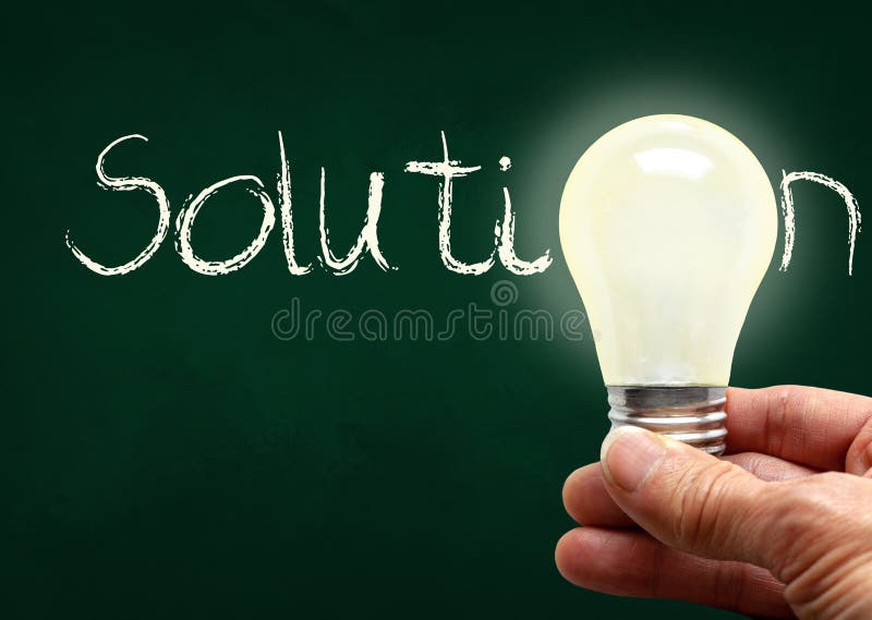 Hand Holding Lighted Bulb with Solution on Chalk Board and Copy Space ...