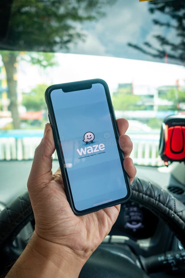 A Man Holding the IPhone X with Waze Navigation App Inside the Car ...