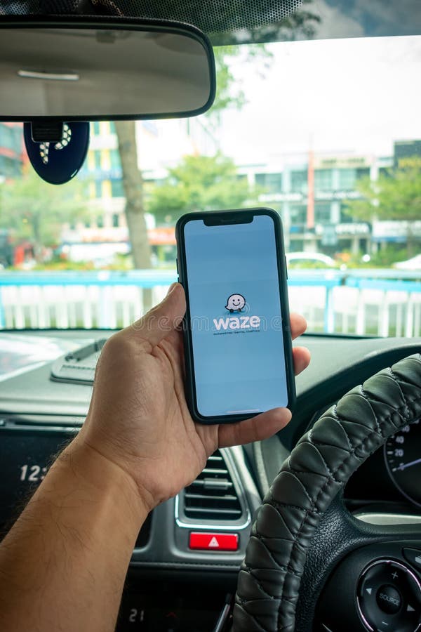 A Man Holding the IPhone X with Waze Navigation App Inside the Car ...