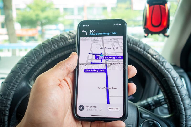 A Man Holding the IPhone X with Waze Navigation App Inside the Car ...