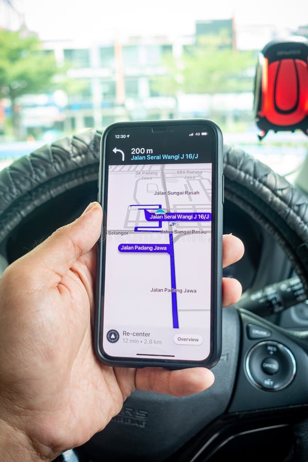 A Man Holding the IPhone X with Waze Navigation App Inside the Car ...