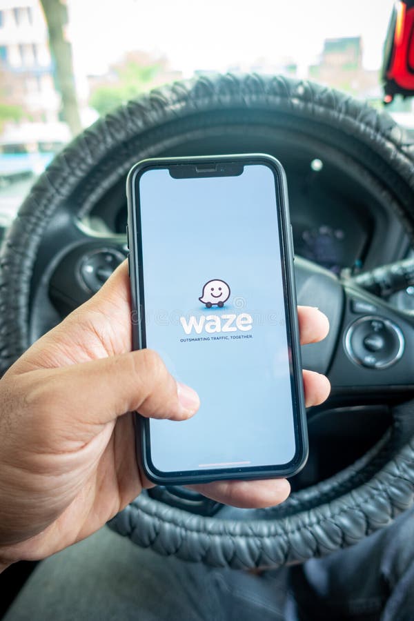 A Man Holding the IPhone X with Waze Navigation App Inside the Car ...