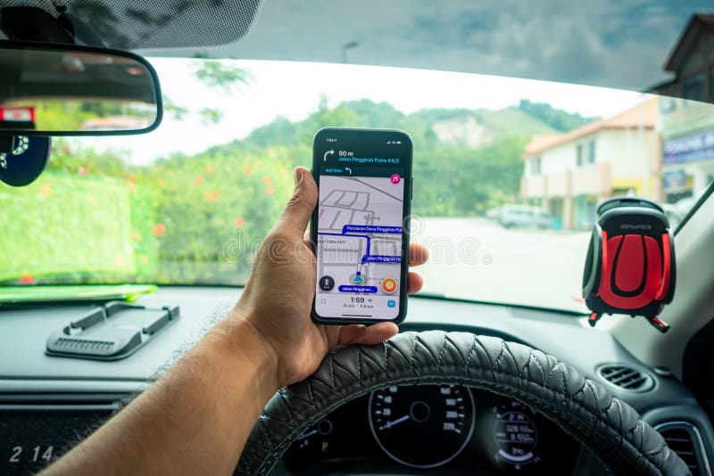 A Man Holding the IPhone X with Waze Navigation App Inside the Car ...