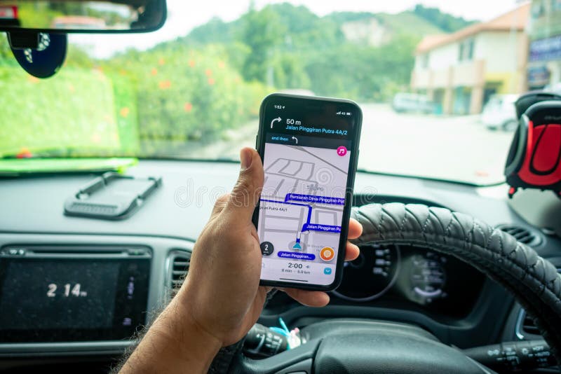 A Man Holding the IPhone X with Waze Navigation App Inside the Car ...