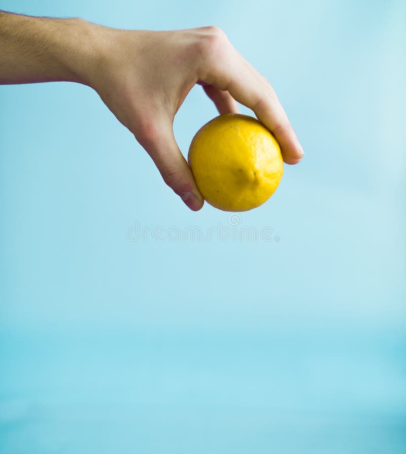 A Man is Holding a Lemon Against a Blue Background Stock Photo - Image ...