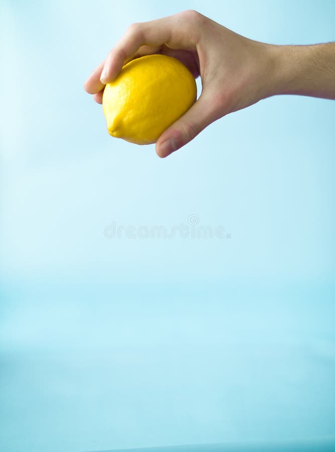 A Man is Holding a Lemon Against a Blue Background Stock Image - Image ...
