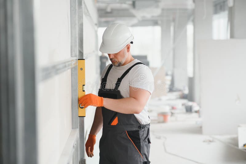 Man Holding Level Against Plasterboard, Interior Drywall. Attic ...